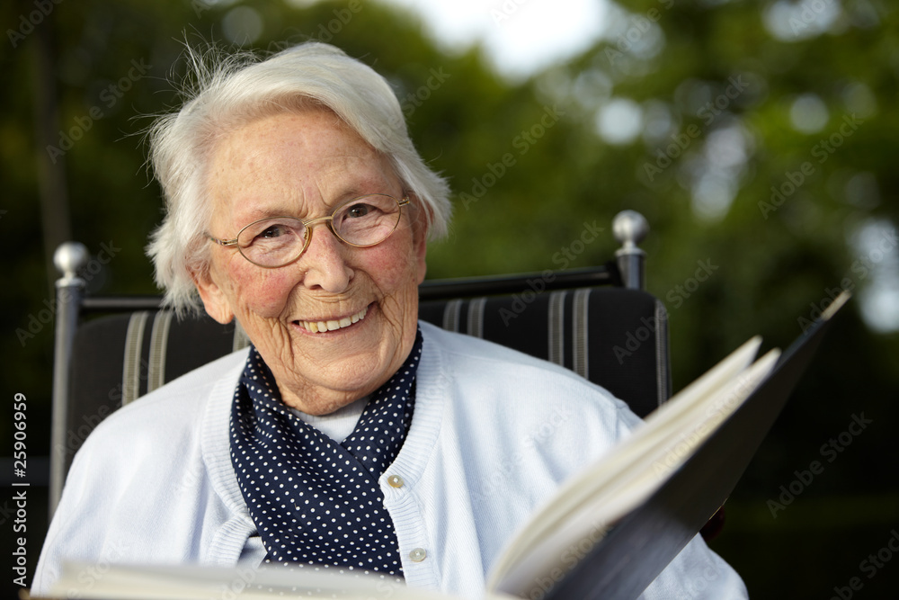 Stock-Foto „Nette alte Dame mit Buch lächelnd“ | Adobe Stock
