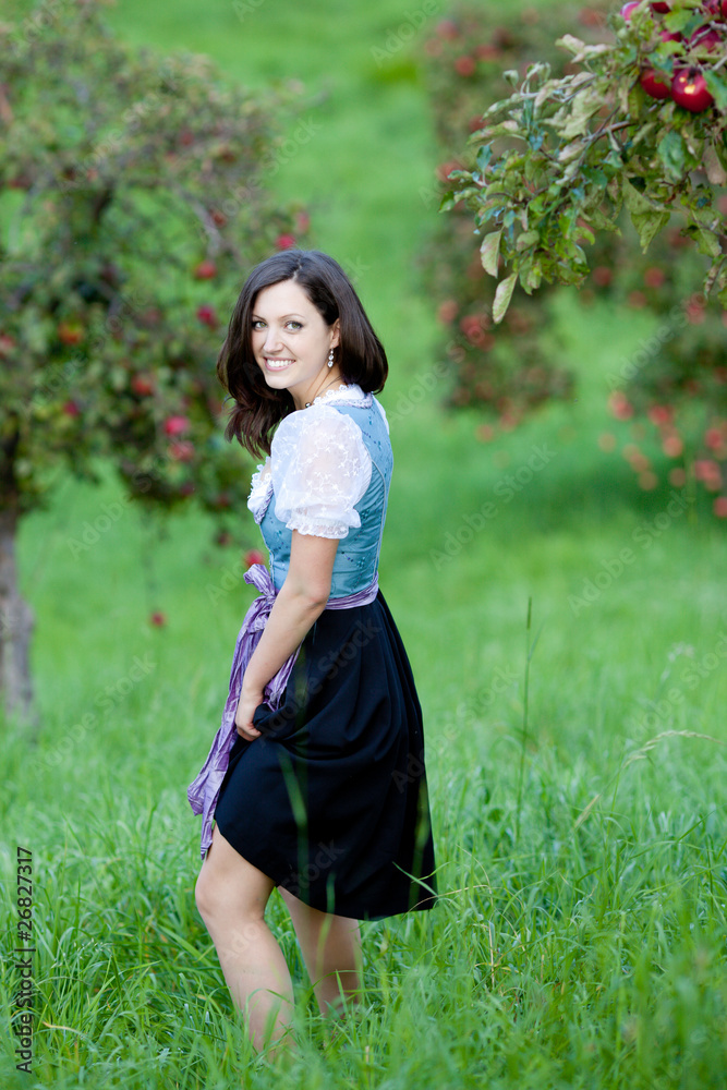 Stock-Foto „Frau zwischen Apfelbäumen zieht ihren Rock hoch“ | Adobe Stock