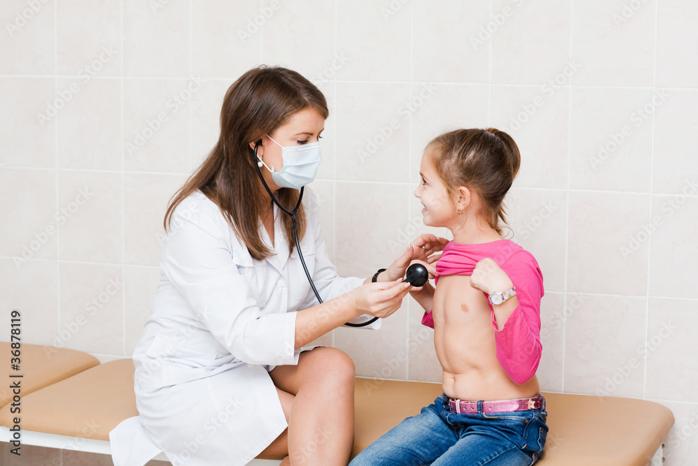 Female doctor examining child with stethoscope at clinic Stock Photo ...