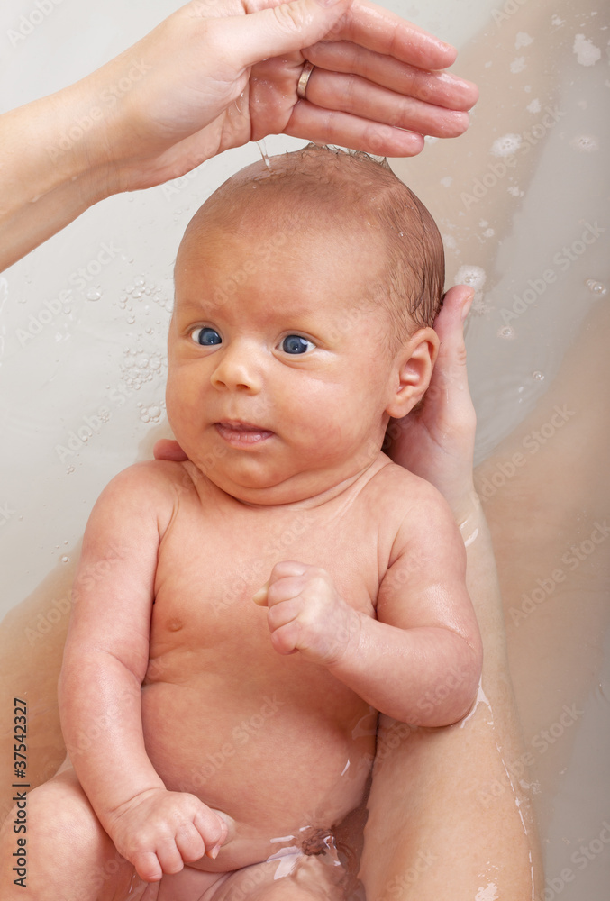 Stock Foto newborn baby girl having her first bath. Adobe Stock