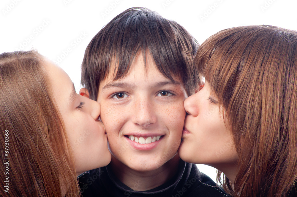 Two pretty girls kissing smiling boy in the cheeks Stock Photo | Adobe Stock