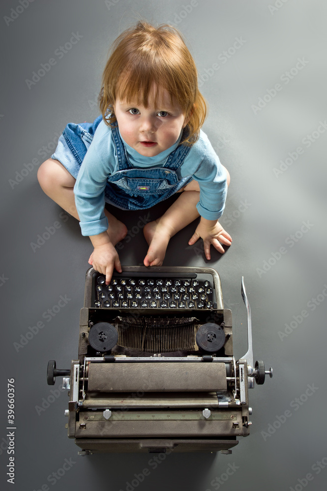 Cute little baby with retro style typewriter Stock Photo | Adobe Stock