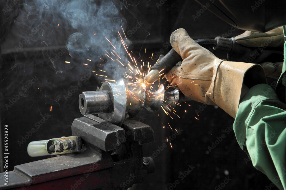 Welder doing arc welding of a steel shaft with helicoid Stock Photo ...