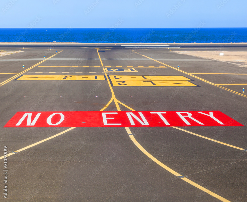 no entry sign at the runway of the airport with ocean in backgro Stock ...