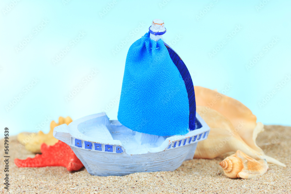 Blue toy ship on sand, on blue background Stock Photo | Adobe Stock