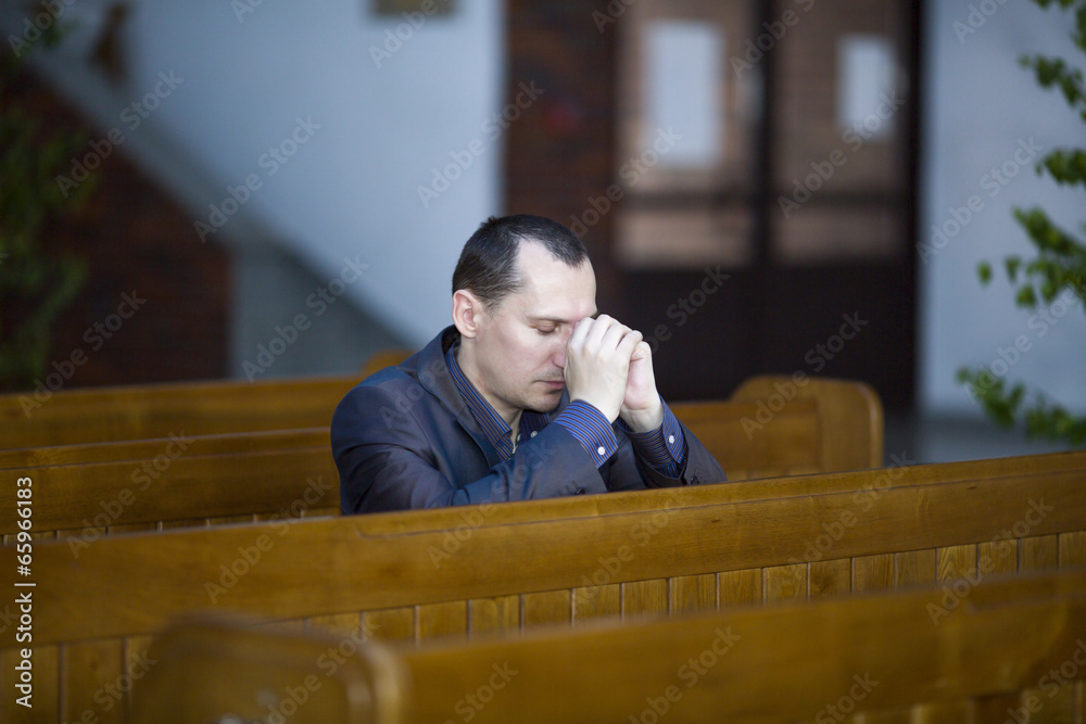 Foto de Stock Man praying in church | Adobe Stock