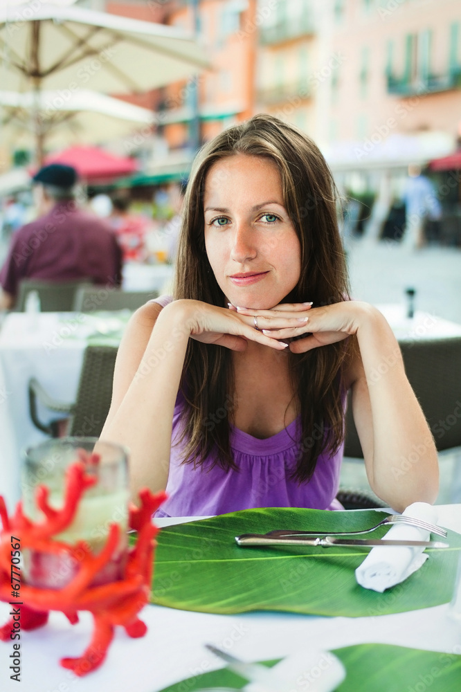 Beautiful young brunette girl sitting behind table in the outdoo Stock ...
