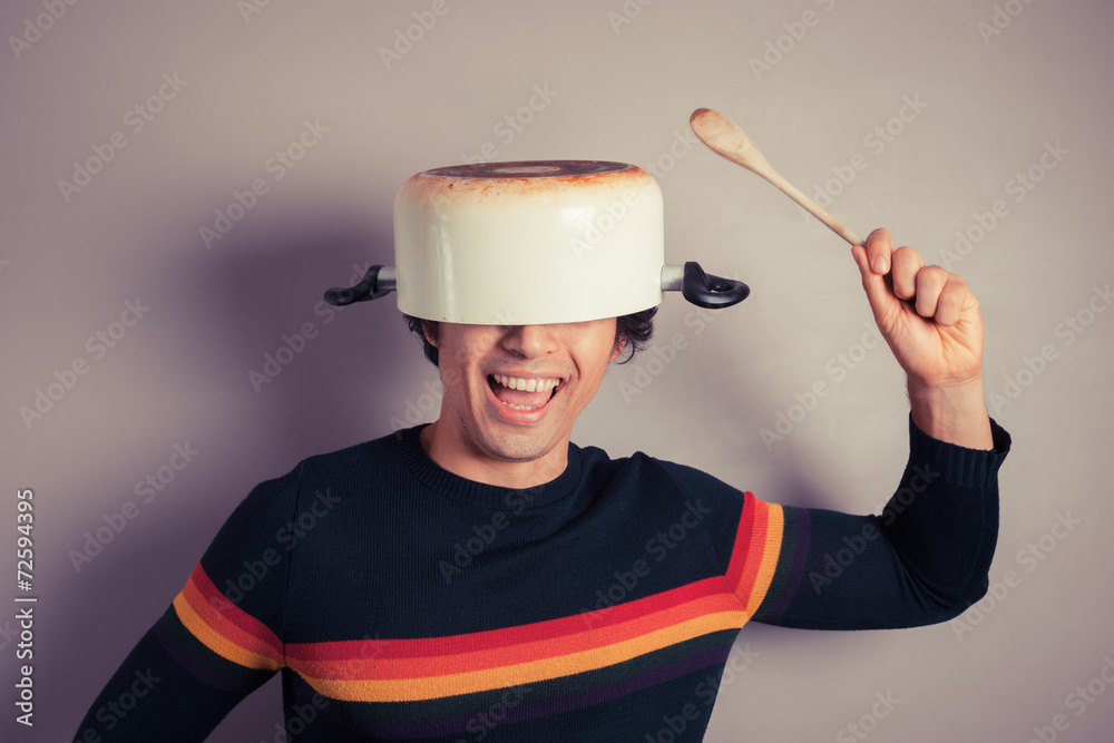Foto de Stock Silly young man with pot on his head | Adobe Stock