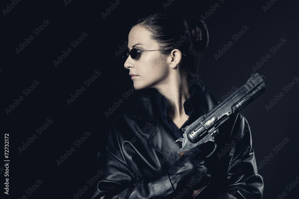 Attractive female agent with raised gun Stock Photo | Adobe Stock