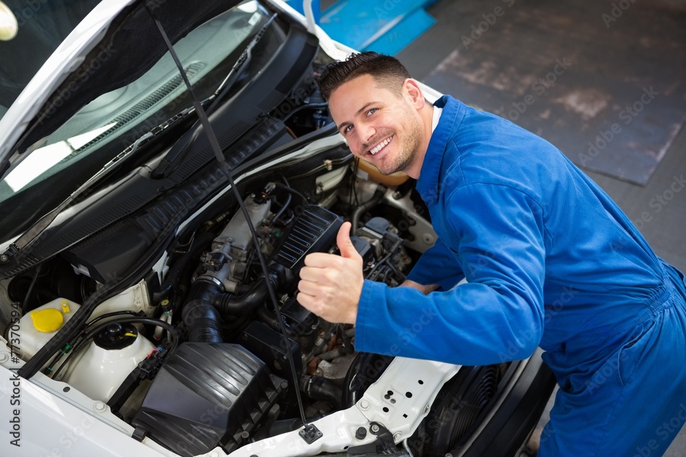 Mechanic examining under hood of car Stock Photo | Adobe Stock