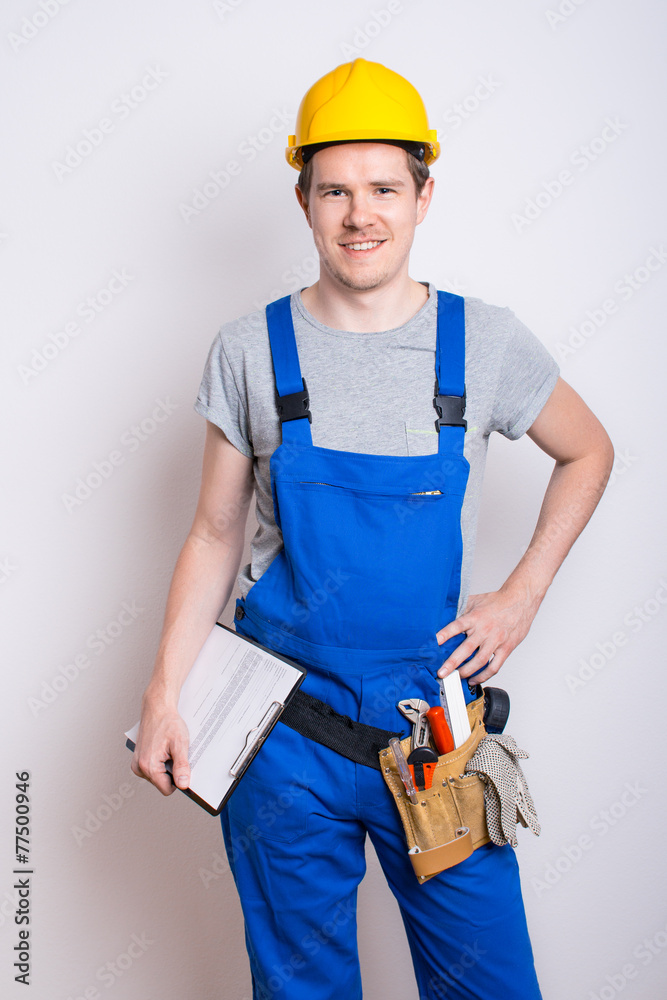 Foto de Stock Arbeiter im Blaumann mit Klemmbrett | Adobe Stock