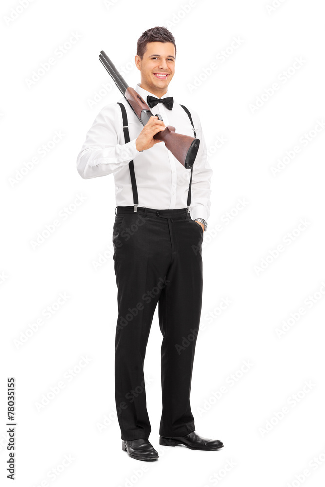 Elegant guy holding a shotgun over his shoulder Stock Photo | Adobe Stock