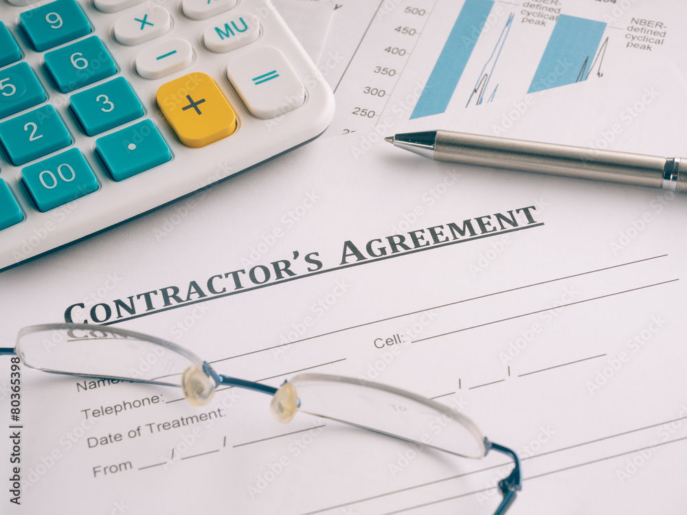 contractor's agreement on the desk. Stock Photo | Adobe Stock