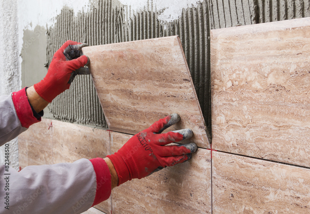 Ceramic Tiles. Tiler placing ceramic wall tile in position Stock Photo ...