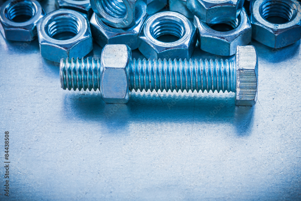 Vertical view of threaded screw nuts and bolts on metallic backg Stock ...