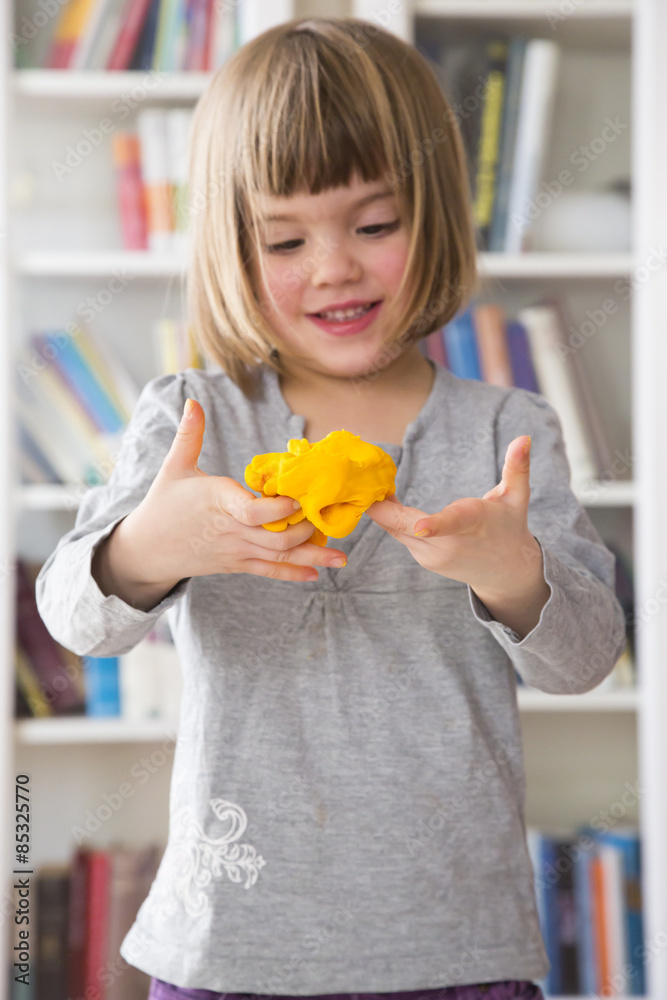 Little girl with yellow modeling clay Stock Photo | Adobe Stock