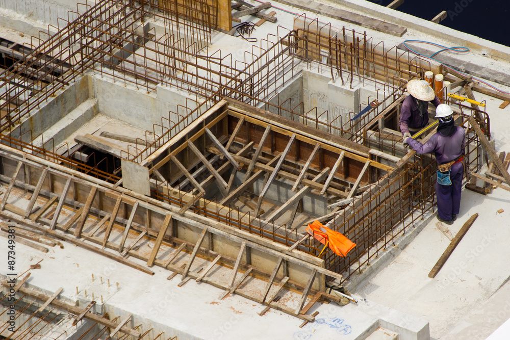 Immigrant workers making reinforcements for concrete foundations ...