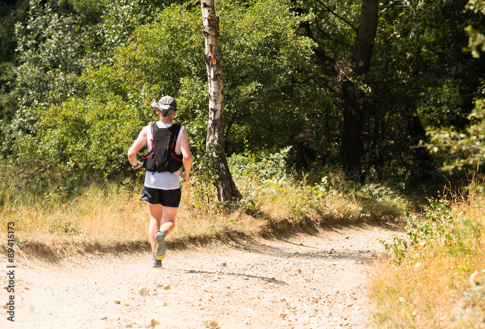 man running in hot summer on the track to the forest Stock Photo ...