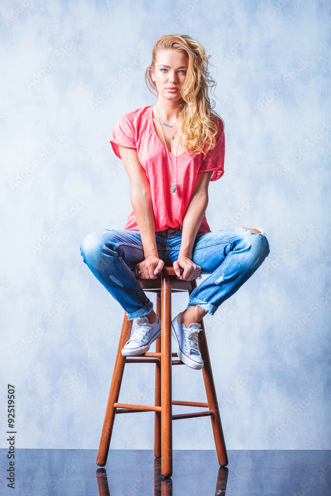 blonde girl posing on a chair with legs wide open Stock Photo | Adobe Stock