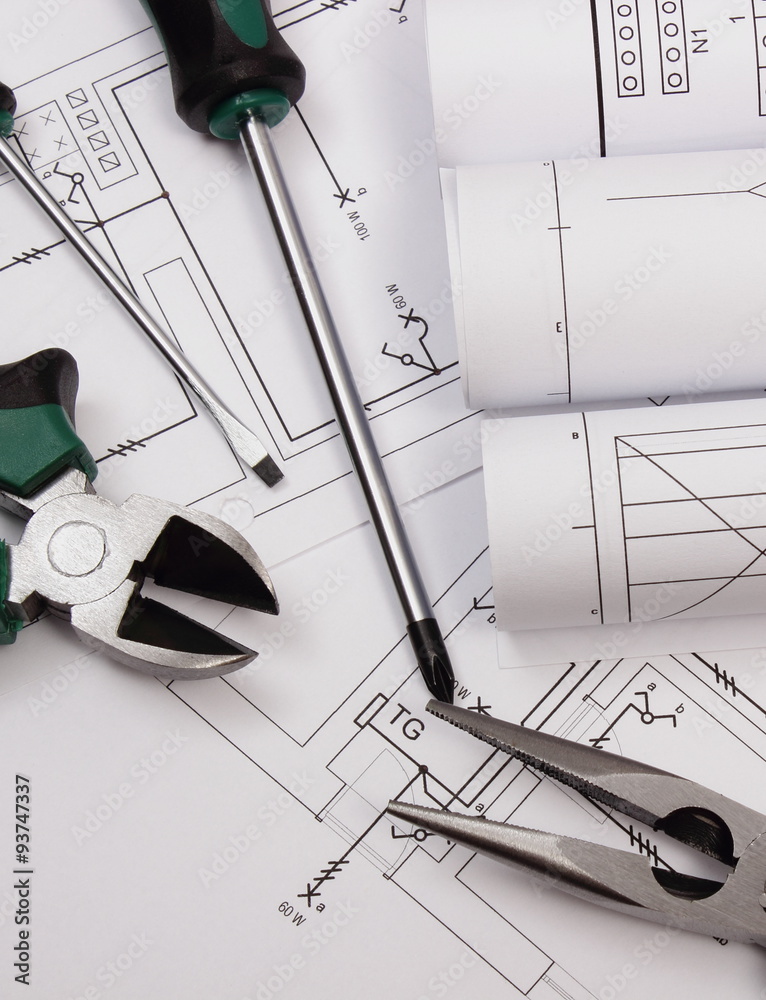 Rolls of diagrams and work tools on electrical construction drawing of ...