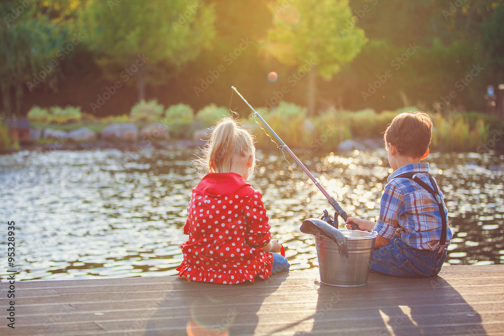 Little boy and girl fishing in a river. Sitting on a wood pontoon Stock ...
