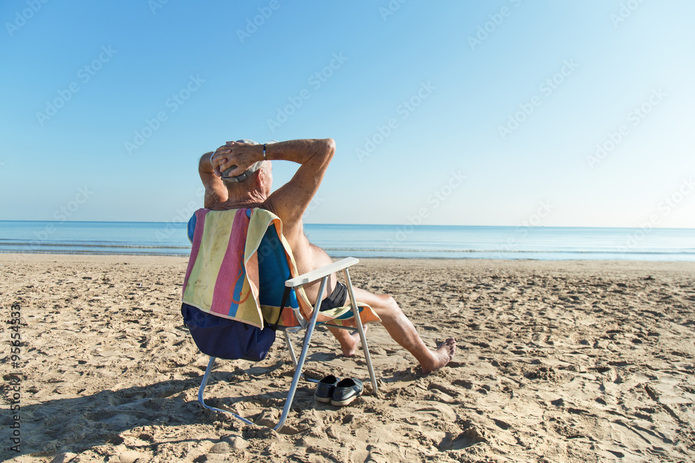 Stock-Foto „Old man sunbathing at the beach“ | Adobe Stock