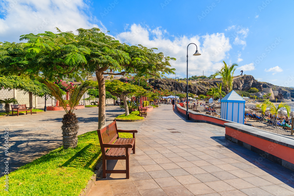 Bench on coastal promenade along a tropical beach in San Juan town on ...