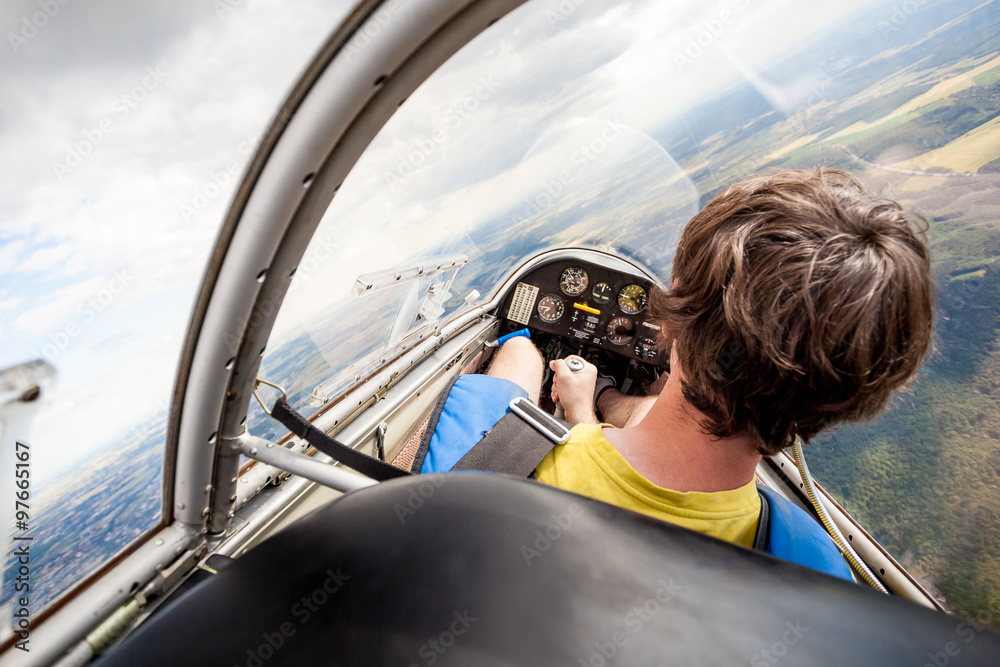 pilot in the cockpit of the plane, glider gliding in the air over ...