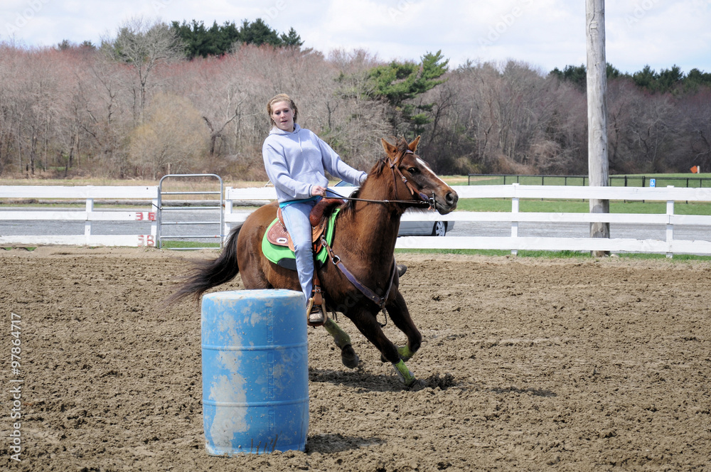 Pretty blonde teenage girl barrel racing; A young teenage girl turns ...