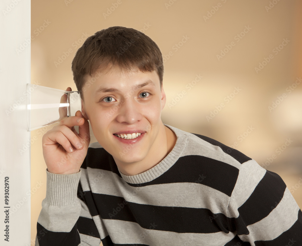 Foto de Stock Man spying by listening through wall with glass | Adobe Stock