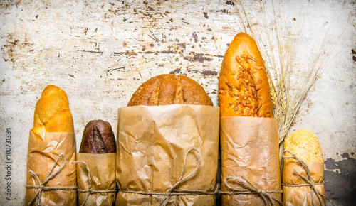 Fresh bread wrapped in paper. On rustic background. - Buy this stock ...