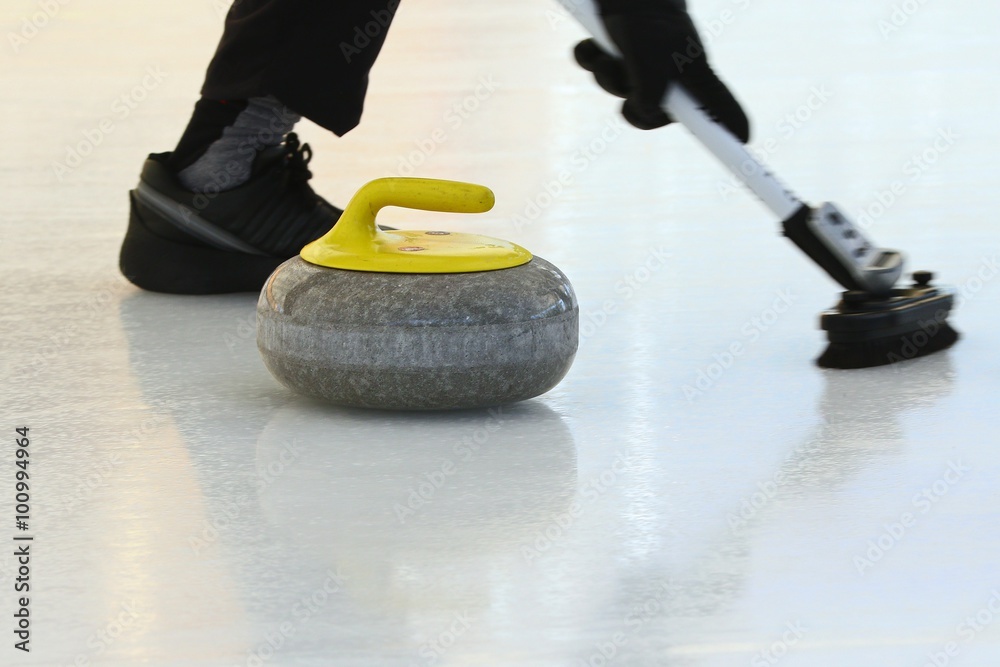 Stock-Foto „Curling stone sliding down the ice with player's feet ...