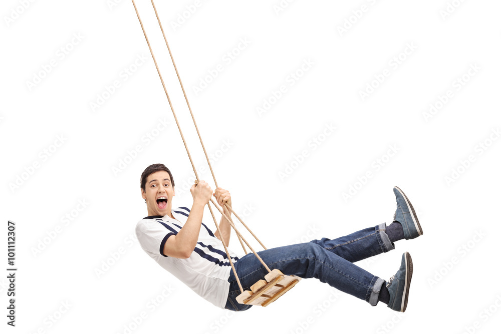 Delighted guy swinging on a wooden swing Stock Photo | Adobe Stock