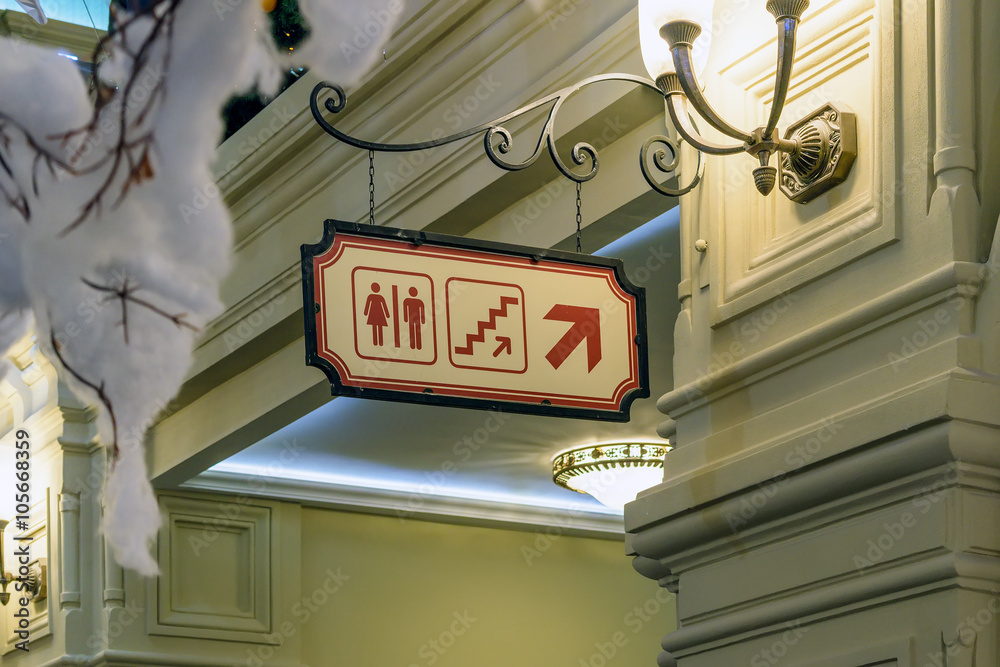 Signboard with direction indicator to the public toilet, hanging Stock ...