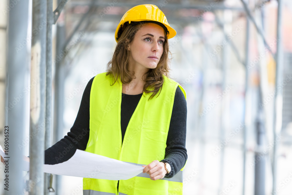 Female architect with helmet and safety jacket on construction site ...