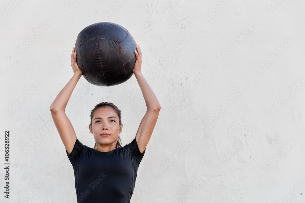 Fitness crossfit girl holding medicine ball above head for shoulder ...