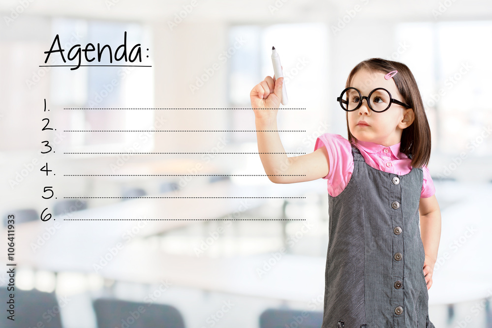Cute little girl wearing business dress and writing blank agenda list ...