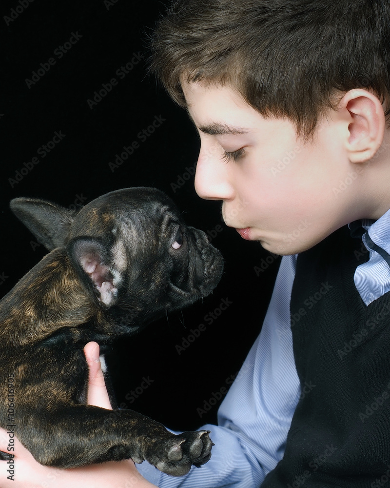 Portrait of a teenage boy with a dog. The boy looks at the French ...