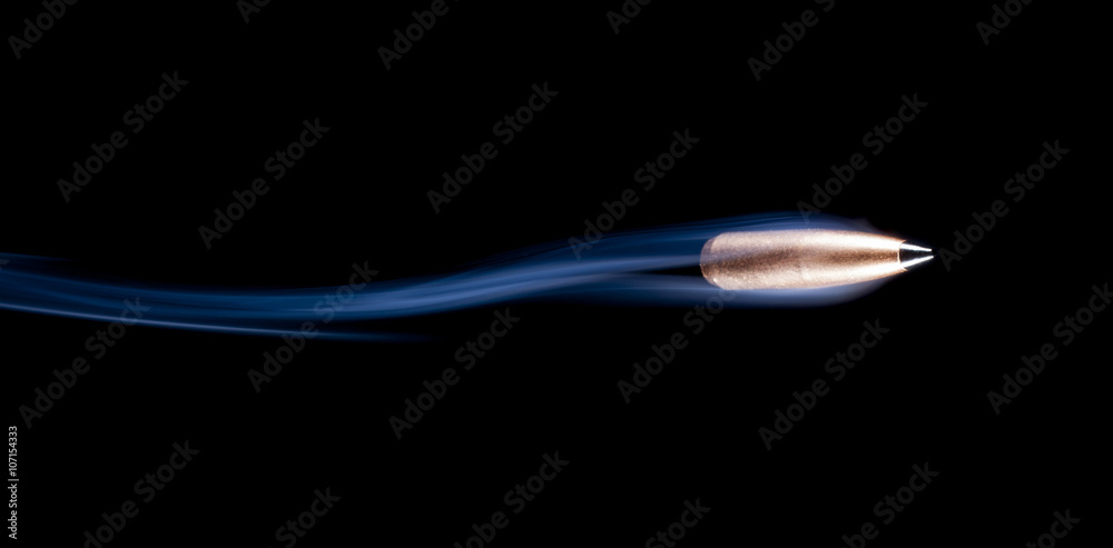 Flying copper jacketed bullet with blue smoke trailing behind on a ...