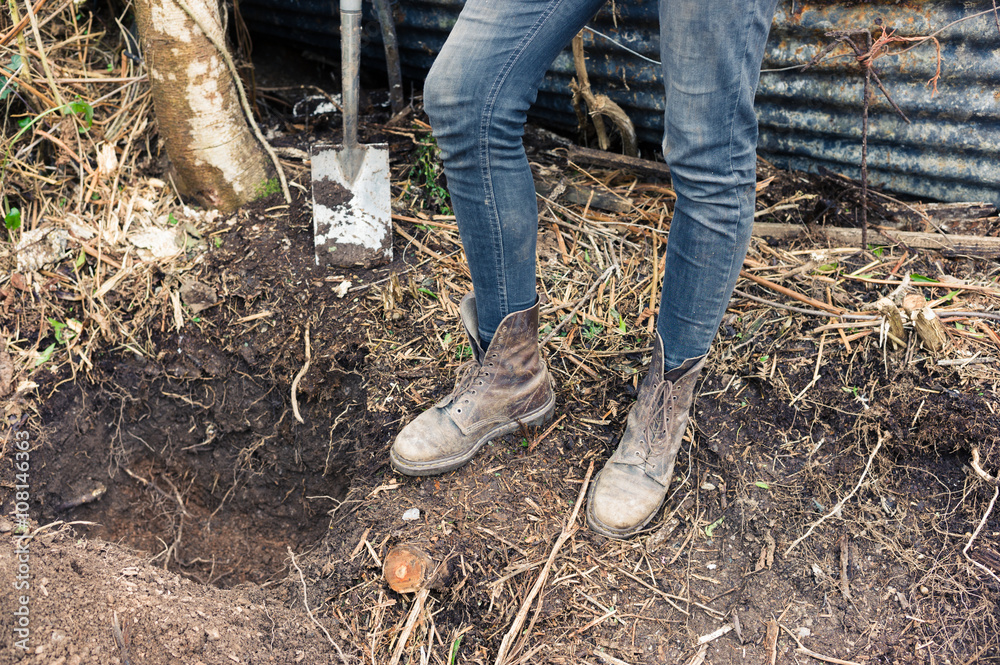 Feet of person standing by hole with spade Stock Photo | Adobe Stock