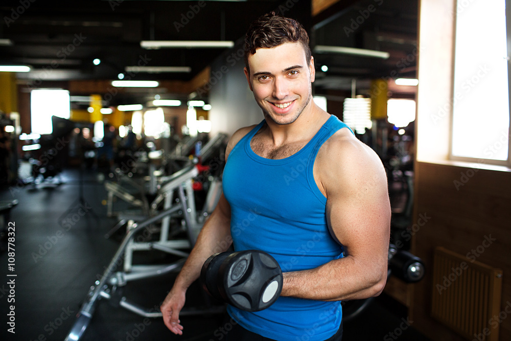 Стоковое фото «Muscular bodybuilder guy doing exercises with dumbbells.Strong Athletic Man ...