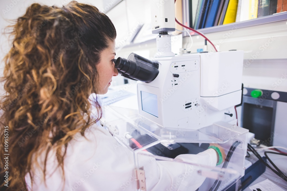 Female scientist using FTIR spectrophotometer, looking at thin film ...