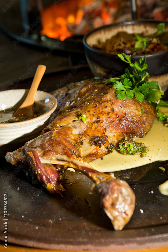 Delicious free range roasted goat shoulder served on a rustic metal ...