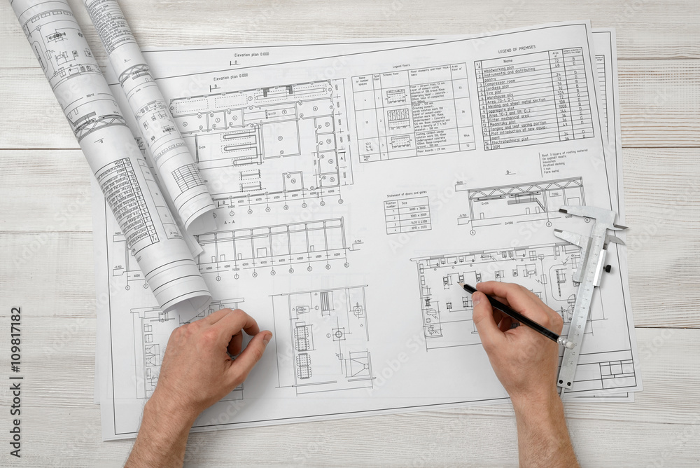 Hands of man holding a pencil over drawing layout in top view. Stock ...