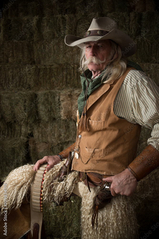 Old western cowboy with wooly chaps and pistols Stock Photo | Adobe Stock