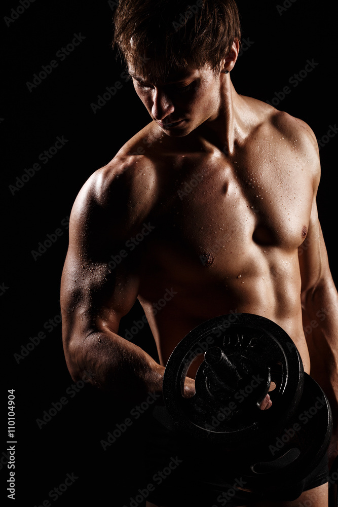 Muscular and fit young bodybuilder fitness male model posing over black ...