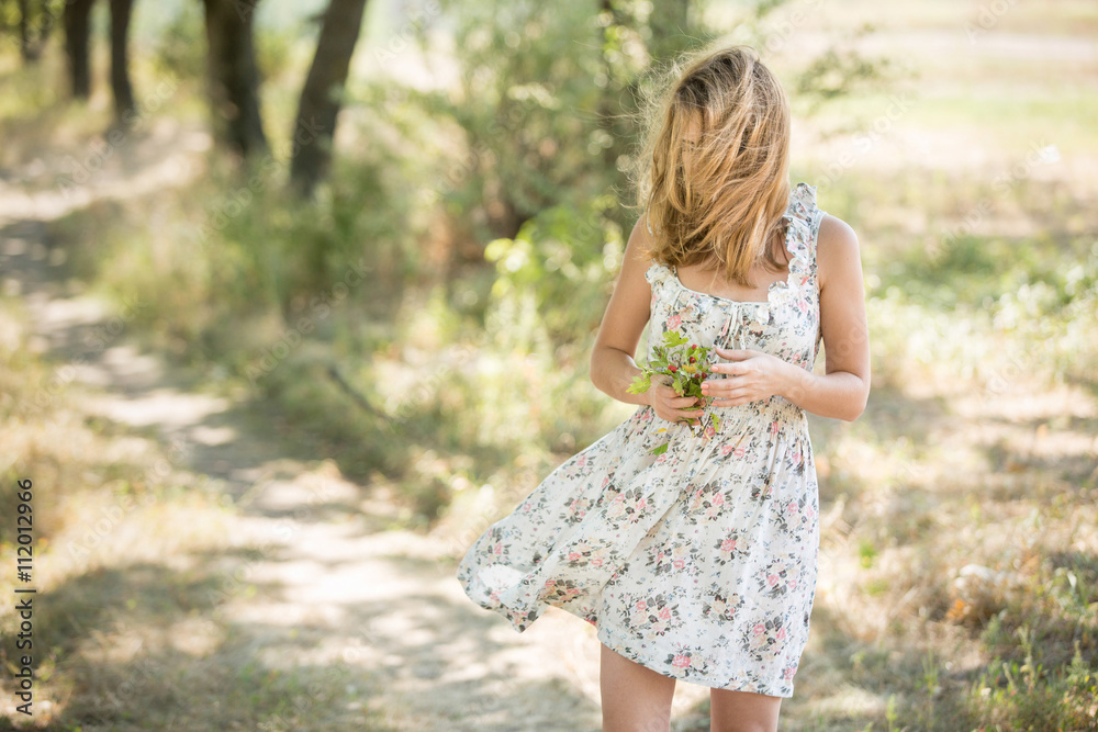 Girl jumping, dancing, spinning in an oak alley. The wind blew her hair ...