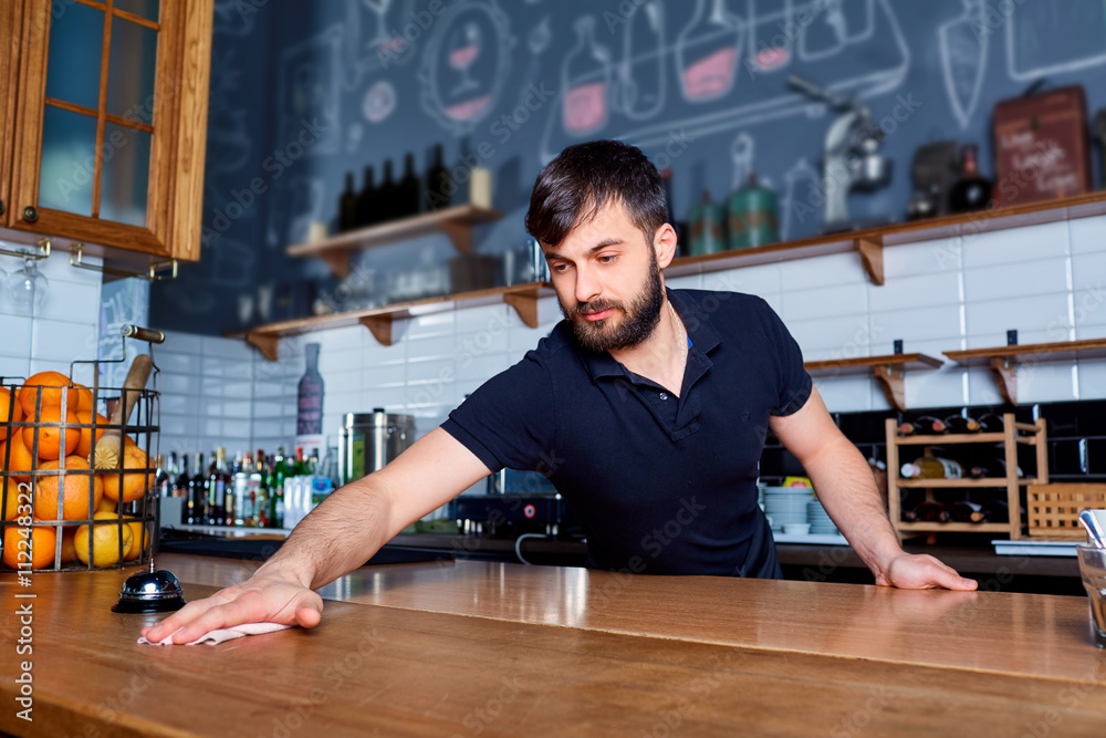 Bartender wiping down bar counter Stock Photo | Adobe Stock