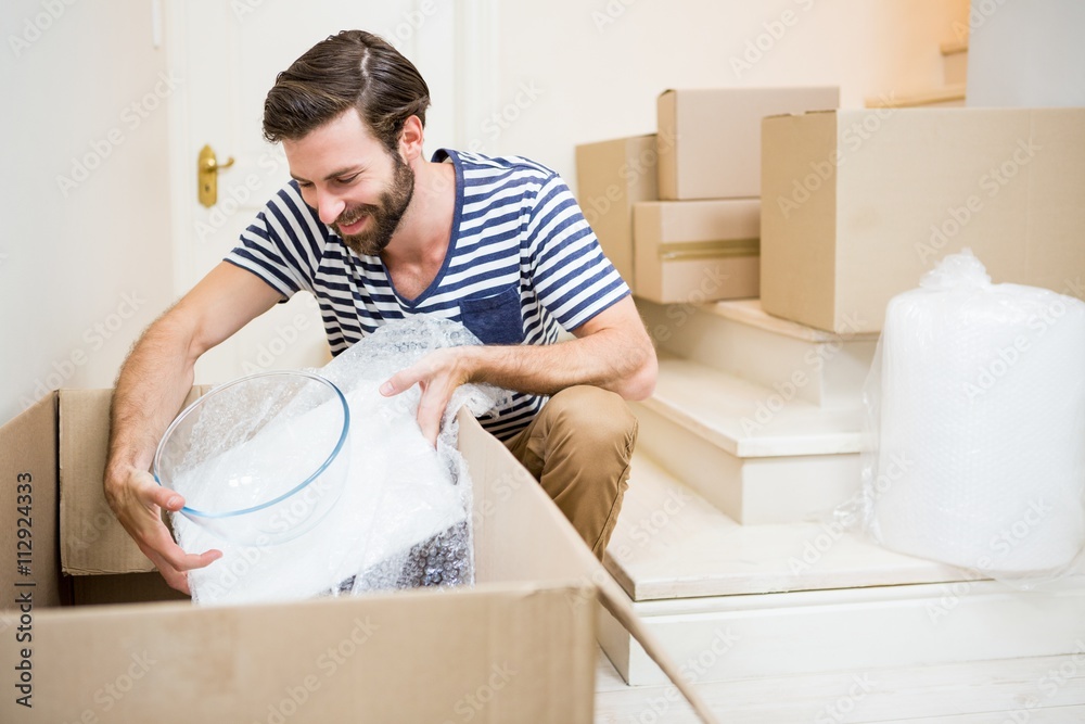 Young man unpacking carton boxes Stock Photo | Adobe Stock