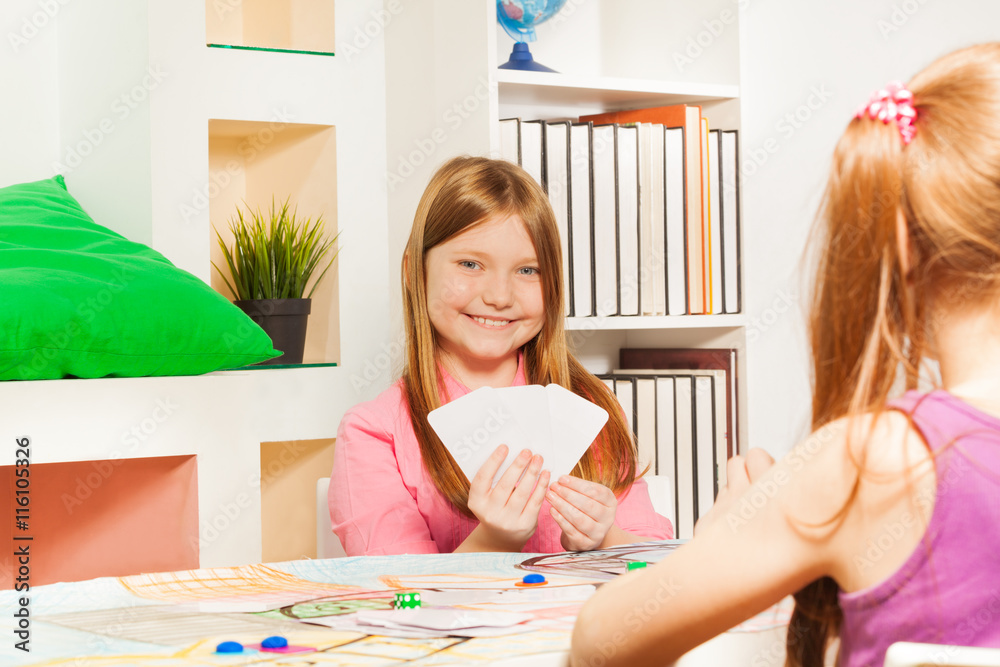 Happy girl playing cards with friends Stock Photo | Adobe Stock
